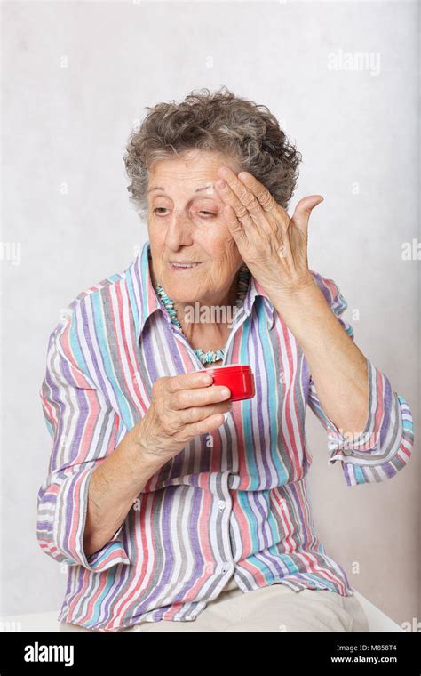 Senior Woman Between 70 And 80 Years Old And A Box Of Face Cream Stock