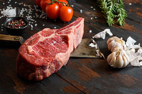 Steak Koboi Mentah Di Latar Belakang Meja Vintage Kayu Gelap Ribeye