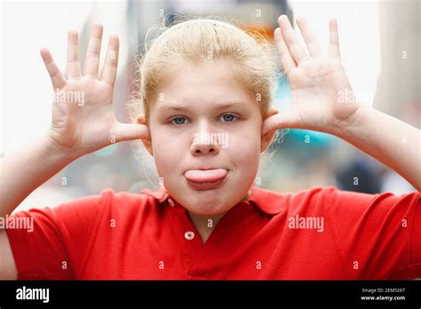 Portrait Of A Teenage Girl Sticking Her Tongue Out With Her Fingers In