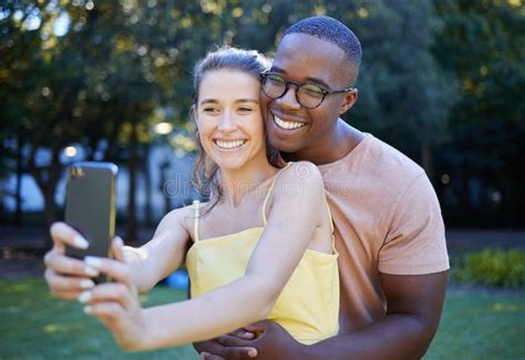 Selfie Phone And Interracial Couple Hug In Park Enjoying Weekend