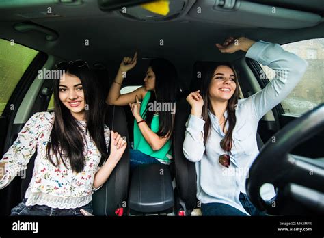 Three Girls Driving In A Car Dancing And Having Fun In City Street