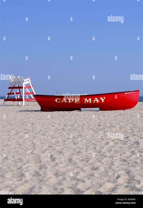 Bright Red Lifeboat And Empty Lifeguards Raised Chair On Beach At Cape