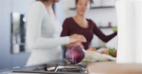 Happy Biracial Lesbian Couple Unpacking Grocery Shopping And Talking In