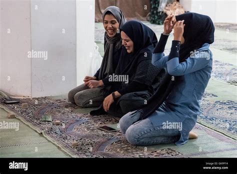 Young Iranian Women Wearing Hijabs Kneel To Pray With Their Cell Phones