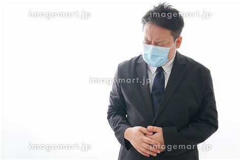 マスクをして腹痛に苦しむ男性の写真素材 [178251334] イメージマート