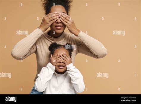 African Mother And Daughter Posing And Covering Their Eyes Isolated