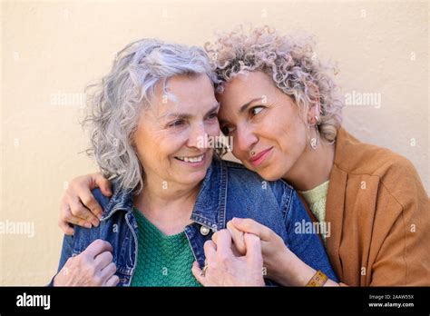 Portrait Of A Senior Mother With Her Adult Daughter Embracing Outdoors