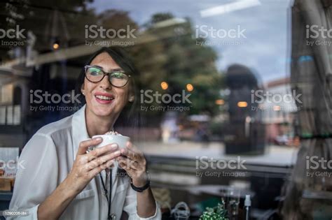 One Woman A Modern Mature Lady With Black Hair Is Drinking Coffee In A