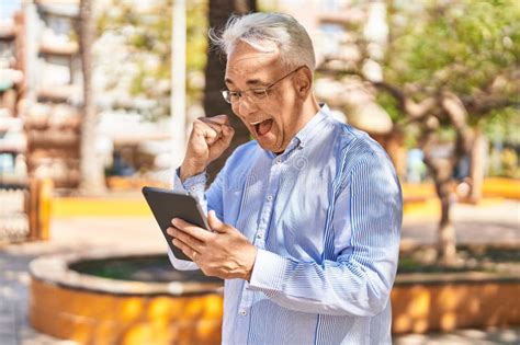 Senior Man Smiling Confident Using Touchpad At Park Stock Image Image