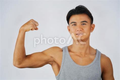 カメラ目線で力こぶを見せるグレーのランニングシャツの男性 No 25609967｜写真素材なら「写真ac」無料（フリー）ダウンロードok