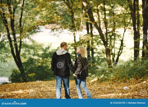 Romantic Couple Walking In A Forest Holding Hands And Posing For A