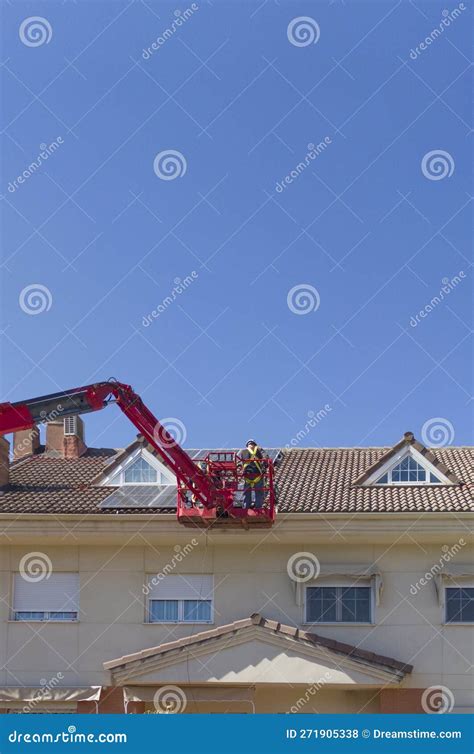 Workmen Installing Solar Panels On The Roof Of A Terraced House Stock