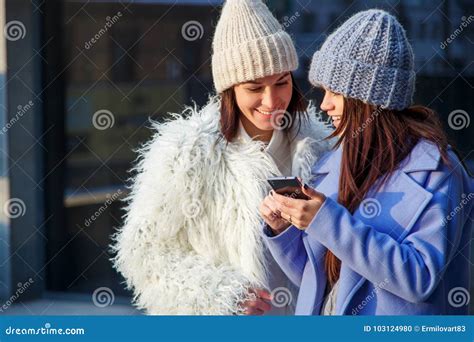 Two Happy Women Friends Sharing Social Media In A Smart Phone Outdoors