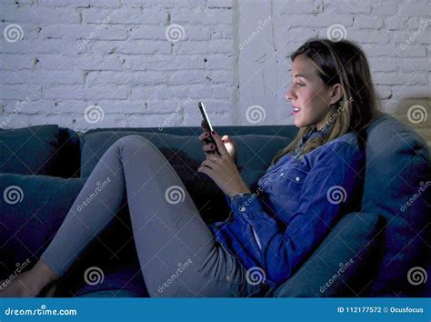 Young Attractive 20s Woman Lying On Home Sofa Couch Using Internet On