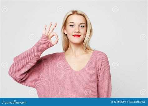 Portrait Of A Happy Young Girl Showing Ok Gesture And Winking Stock