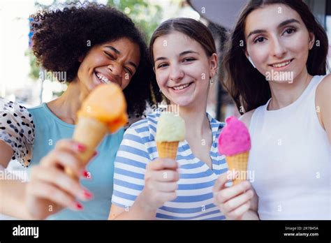Three Cheerful Multiracial Female Teenager Girls Holding Colorful Ice