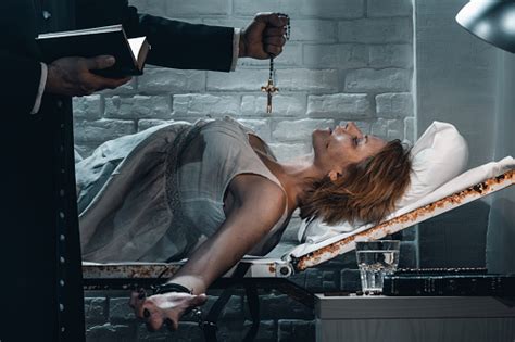 Old Priest Performing Exorcism Ritual Of Young Possesed Woman Stock