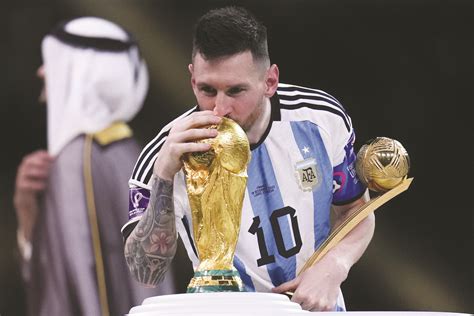 Lionel Messi Kisses The Fifa World Cup Trophy As He Holds The Golden
