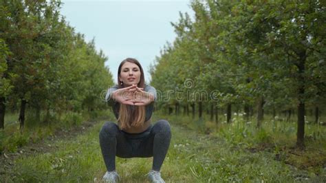 Professional Female Athlete Training Outdoors Doing Jumping Squats To
