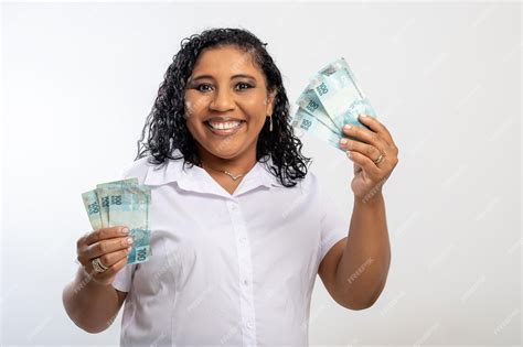 Mulher Sorridente Segurando Notas De 100 Reais Nas Mãos Aponta Para O