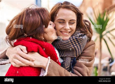 Two Women Mother And Daughter Hugging Each Other Kissing At Street