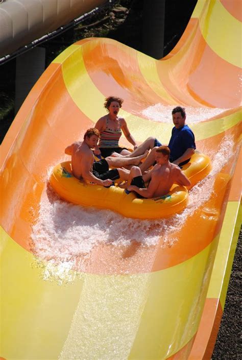Three People Are Riding On An Inflatable Water Slide