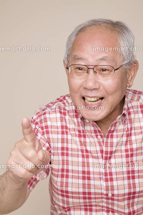 人差し指をさしている老人の写真素材 [24030699] イメージマート