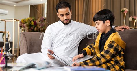تلميذ سعودي خليجي يدرس في المنزل مع والده ،الذي يتبع معه حصص الاونلاين