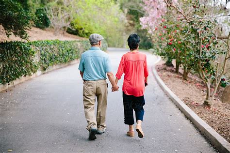 Asian Senior Couple Walking And Holding Hands By Stocksy Contributor