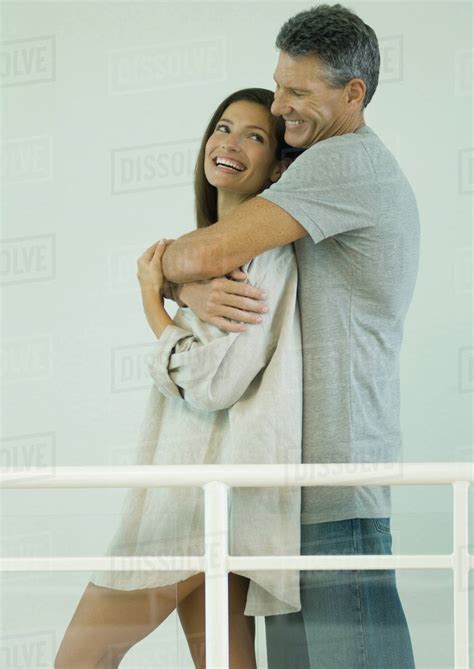 Couple Smiling At Each Other Man Standing Behind Woman With Arms