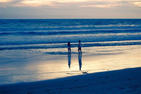 People Walking Along The Beach At Sunset By The Sea Beautiful Evening