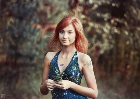 Фото Красивая рыжая девушка с тату на руке держит цветы фотограф Павел