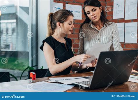 Female Secretary Looking Concerned While Her Boss Checking Document