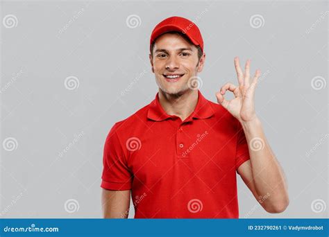 Young Delivery Man Wearing Uniform Smiling While Showing Ok Sign Stock