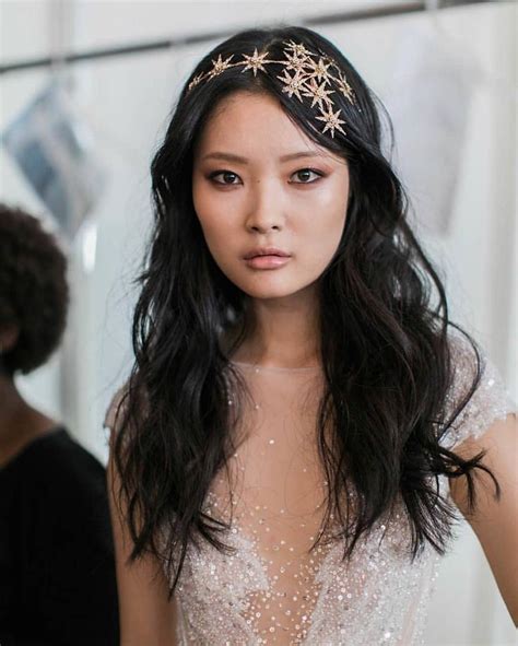 A Woman With Long Black Hair Wearing A White Dress And A Gold Head