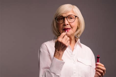 Premium Photo Bright Color Blonde Stylish Senior Woman Putting Lip