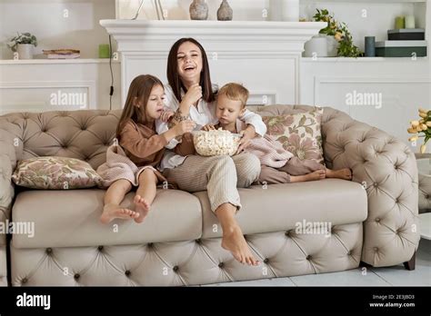 Maman S Assoit Sur Le Lit Avec Son Fils Et Sa Fille Et Regarde Un Film