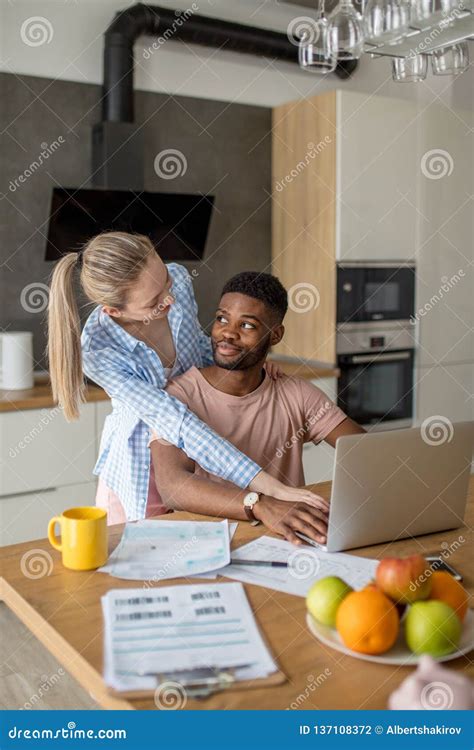 Young Interracial Couple Using Laptop Together Having Breakfast At Home