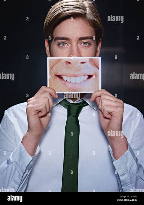 Young Business Man Holding Photo Of Toothy Smile On Black Background