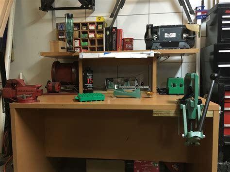 A Workbench In A Garage With Tools On The Table And Shelves Above It