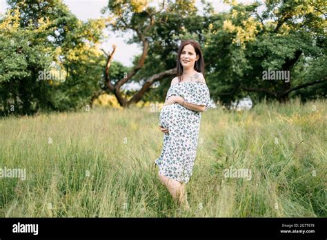 Pretty Caucasian Woman In Summer Dress Caressing Her Pregnant Belly