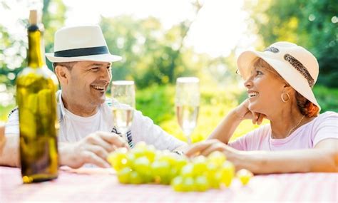 Premium Photo Happy Couple Drinking White Wine On A Picnic Smiling At
