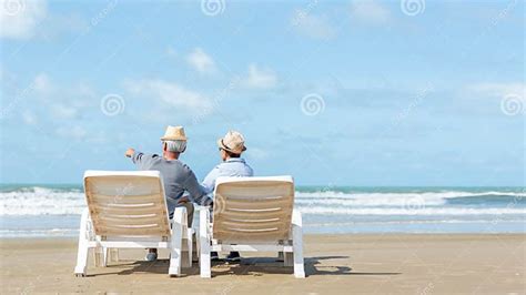 Asian Lifestyle Senior Couple Hug And Pointing On The Beach Happy In