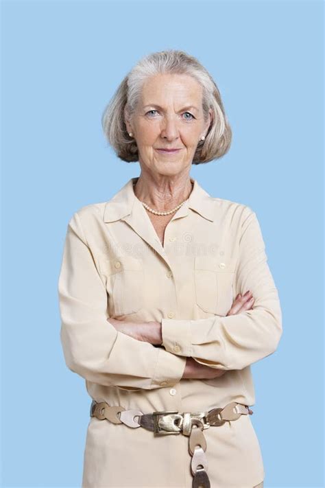 Portrait Of Smiling Senior Woman In Casuals With Arms Crossed Against