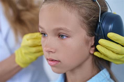 Close Up Of Girl And Doctors Hands Putting On Headphones Stock Image