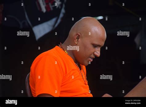 Cute Bald Model Wearing Orange T Shirt Smiling Looking At The Camera