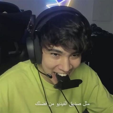 A Young Man Wearing Headphones While Sitting In Front Of A Computer