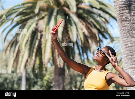 Cheerful African Woman On Summer Attire Taking Selfie On Tropical Site