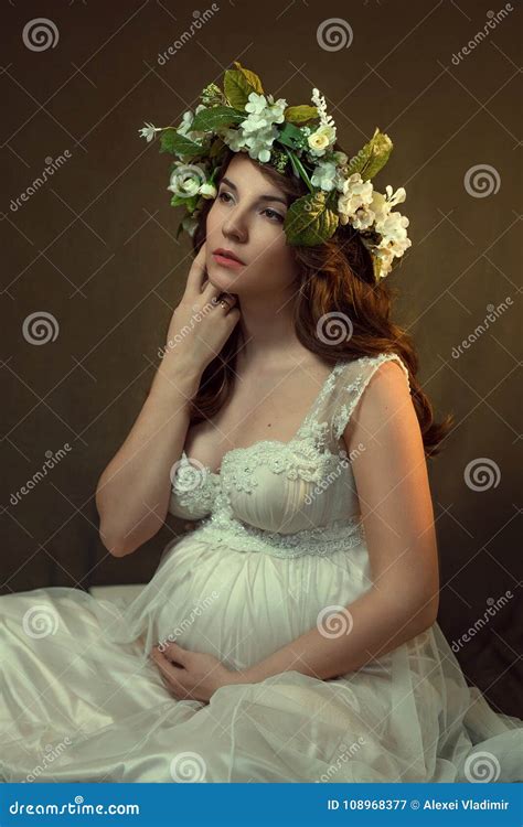 Beautiful Female Portrait Of A Pregnant Woman In White Dress Stock