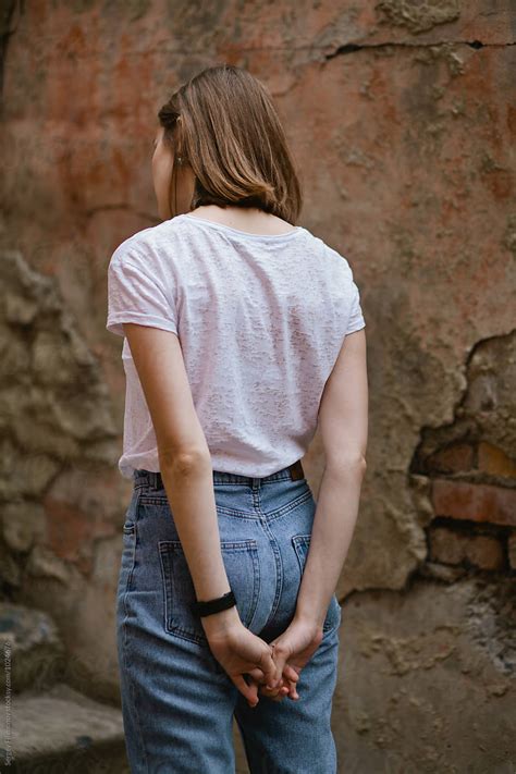 Anonymous Woman Standing With Her Hands Behind Her Back By Stocksy